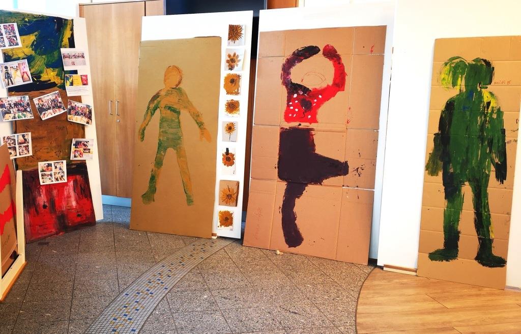 Kinder malen großflächige Porträts auf Pappe